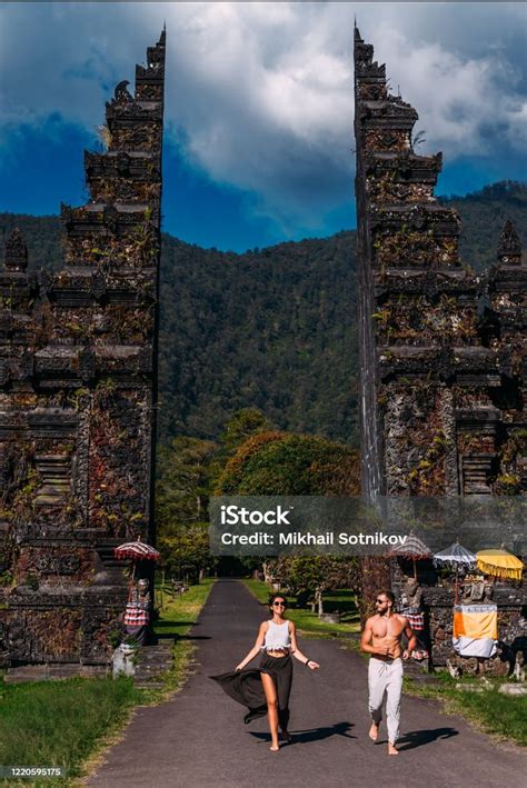 발리 인도네시아 섬을 여행하는 남자와 여자 아시아에서 즐거운 커플 발리 게이트에서 커플 부부는 세계를 여행합니다 해질녘 발리 사원에서 남녀 개념에 대한 스톡 사진 및 기타