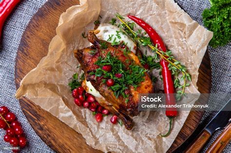 구운 닭고기는 양피지로 감싼 나무 쟁반에 놓여 있습니다 트레이는 칼과 포크 고추 건포도 옆에 있는 회색 캔버스에 있습니다 고기에 대한 스톡 사진 및 기타 이미지 Istock