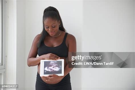 Pregnant Black Woman Showing Sonogram On Digital Tablet High Res Stock