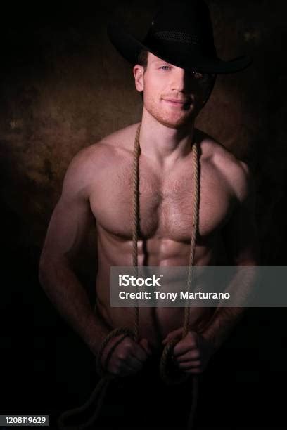 정의된 Pecs와 식스팩 복근 로프를 들고 있는 근육질의 팔을 보여주는 모자를 쓰고 있는 잘생긴 카우보이 가수에 대한 스톡 사진 및 기타 이미지 Istock