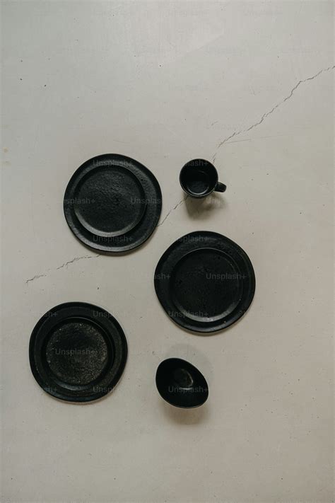 테이블 위에 놓인 한 무리의 검은 접시 사진 Unsplash의 검정 이미지