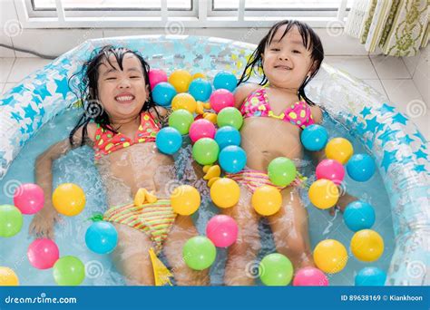Happy Asian Chinese Little Sisters Playing In The Inflatable Poo Stock