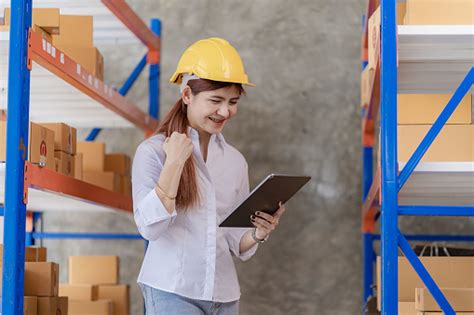 한 아시아 여성이 작은 창고의 선반에서 소포를 확인합니다 상품을 배달하기위한 물류 서비스를위한 온라인 상점 바코드를 발송하기