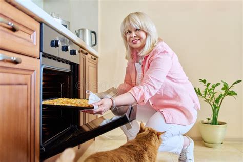 Mujer Madura Cocinando Carne En Horno En Casa En La Cocina Foto De