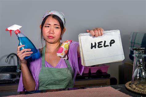 젊은 슬 프 고 우울 아시아 한국 여자 도움말 기호 및 스프레이 청소기 병 느낌 스트레스와 좌절 집에서 가사 일상적인 스트레스 개념에 부엌 일 가사 집안일에 대한 스톡 사진