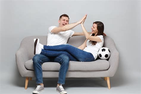 웃는 커플 여자 남자 축구 팬은 축구 공을 좋아하는 팀을 지원 응원 회색 배경에 고립 서로 5 주는 사람들의 감정 스포츠 가족 레저 라이프 스타일 개념입니다