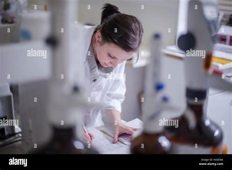 Woman Taking Notes In Lab Stock Photo Alamy