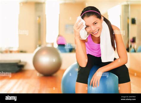 Asian Fitness Girl Training At Gym Wiping Sweat With Towel Post Workout