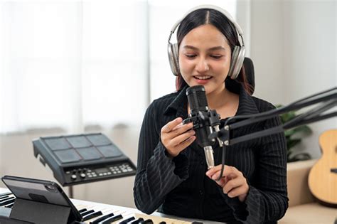 믹싱 마스터링 음악을 위한 콘덴서 마이크와 태블릿이 있는 전문 음악가 디지털 레코딩 홈 스튜디오에서 기타와 피아노 키보드로 노래를 작곡하는 음악 작곡가 여성 25 29세에