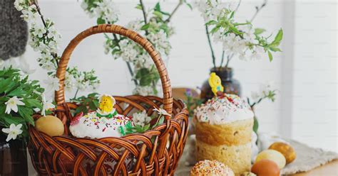 세련된 부활절 달걀 수제 부활절 빵 고리 버들 바구니에 담긴 맛있는 전통 부활절 음식 소박한 테이블의 린넨 냅킨에 피는 봄