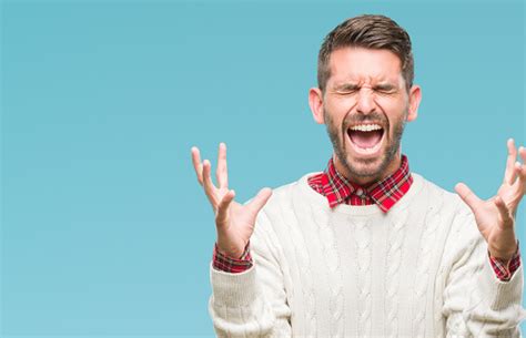 미친 미친 무기와 성공을 위한 축 하 하는 고립 된 배경 위에 겨울 스웨터를 입고 잘생긴 젊은이 제기 하 고 흥분 비명 눈을 폐쇄 우승자 개념 가을에 대한 스톡 사진 및