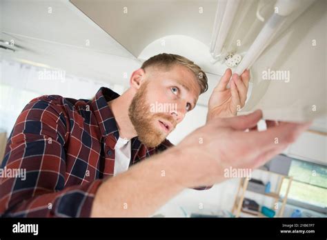 Man Installing A Replacement Fluorescent Bulb Stock Photo Alamy