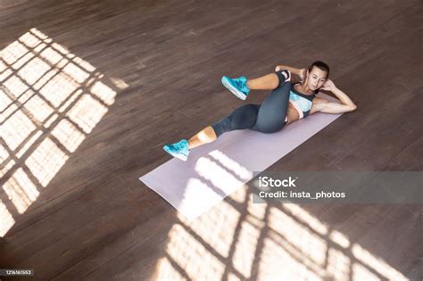 스포티 핏 활동적인 젊은 여성 자전거 크런치 앉아 서 운동 혼자 매트 나무 바닥에 누워 강한 스포츠 여자 착용 액티브 웨어 운동 복 스 코어 근육 운동 스포츠 체육관