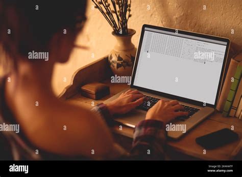 Back View Of Caucasian Female Programmer Siting At Desk Using Laptop
