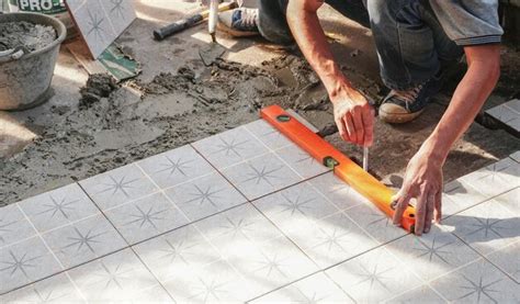 Premium Photo A Man Is Laying Tiles On A Floor With A Tape That Says Tiling