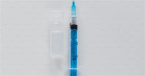 바늘이 튀어 나와있는 작은 파란색 튜브 사진 Unsplash의 주사 이미지