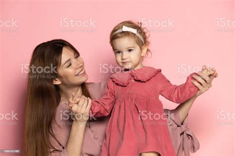 핑크 스튜디오 배경에 고립 된 어머니와 딸을 돌보는 젊은 여성과 유아를 기쁘게 어머니의 날 축하 가족 어린 시절 모성의 개념 2 3 살에 대한 스톡 사진 및 기타 이미지