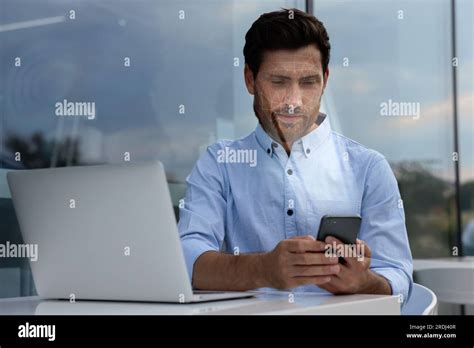 Man Using Smartphone With Facial Recognition System In Cafe Security Application Scanning His