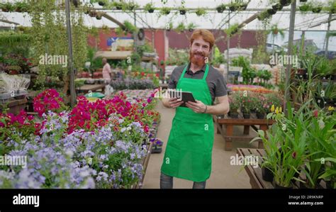 Ein Männlicher Mitarbeiter Von Flower Shop Hält Ein Tablet In Der Hand