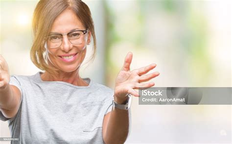 중간 나이 포옹에 대 한 두 팔을 벌려 웃 고는 카메라를 보고 하는 고립 된 배경 위에 안경을 수석 히스패닉 여자 명랑 식 수용 행복입니다 손바닥에 대한 스톡 사진 및 기타