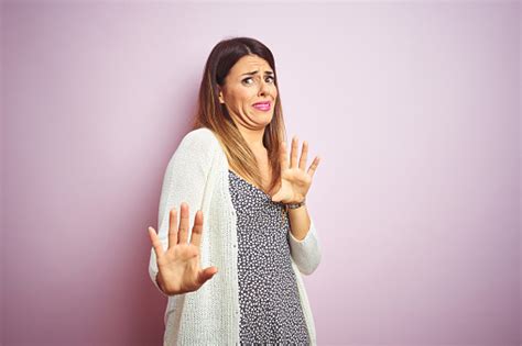 분홍색 고립 된 배경 에 서 젊은 아름다운 여자는 혐오 표정 혐오 와 혐오 얼굴을하고 혐오 반응 때문에 손을 들고 성가신 개념 갈색 머리에 대한 스톡 사진 및 기타 이미지