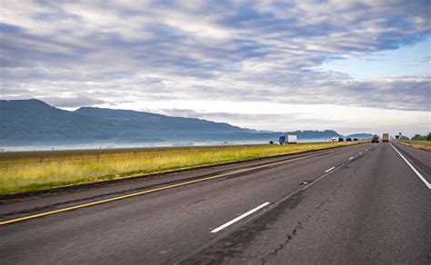 반대 방향으로 직선 분할 고속도로에서 달리는 화물을 운반하는 세미 트레일러가있는 대형 장비 세미 트럭 0명에 대한 스톡 사진 및 기타 이미지 Istock