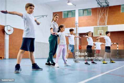 초등학교 체육관에서 체육 수업 시간에 학생들을 돕는 스포츠 교사 교육에 대한 스톡 사진 및 기타 이미지 교육 아이 학교 체육관 Istock