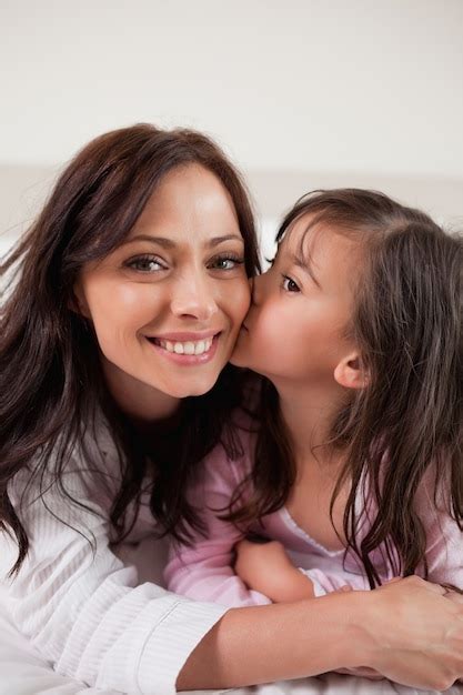 Retrato De Una Niña Besando A Su Madre Foto Premium