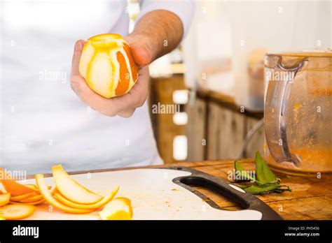 Man cleaning and cutting oranges to squeeze them, preparing juice Stock ...
