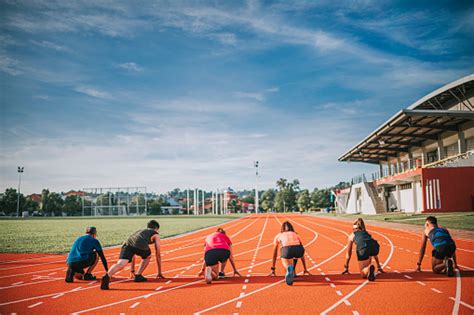 후방 보기 아시아 중국 선수들이 트랙과 필드 스타디움에서 아침에 결승선을 향해 달리기 위해 트랙에서 출발선을 준비하고 줄을 서있습니다 스포츠 트랙에 대한 스톡 사진 및 기타