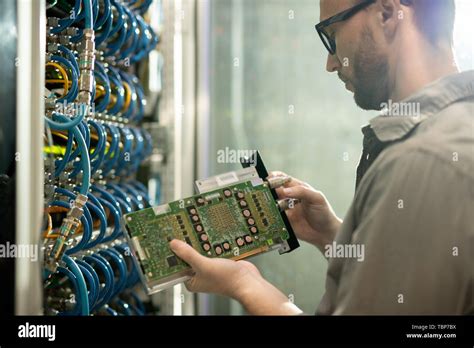 Serious Skilled Young It Engineer Standing At Server Of Database