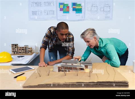 Male And Female Architects Discussing Over Model Structure Of House At Desk Stock Photo Alamy