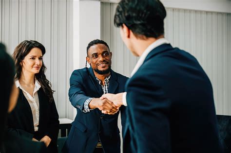 성공적인 사업 파트너십 회의에서 쾌활한 젊은 관리자가 신입 사원과 악수를 합니다 팀워크와 협업을 상징하는 사무실에서의 악수 클로즈업 25 29세에 대한 스톡 사진 및 기타