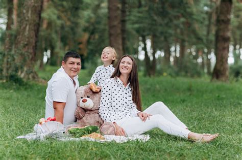 여름 날 공원에서 피크닉에 행복한 미소 젊은 가족 여름 휴가의 개념 아버지 어머니의 날 아기의 날 함께 시간을 보내고 선택적