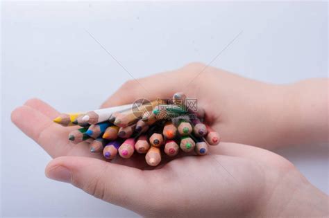 手持彩色铅笔放在白色背景上高清图片下载 正版图片505320631 摄图网