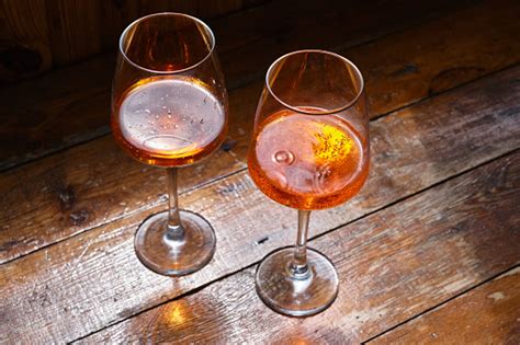 두 잔의 와인이나 아페롤론은 레스토랑의 나무 테이블입니다 여름 휴식 그 순간을 축하하고 즐기십시오 알코올 음료 시음 와인 한 잔 클로즈업 버번 위스키에 대한 스톡 사진 및