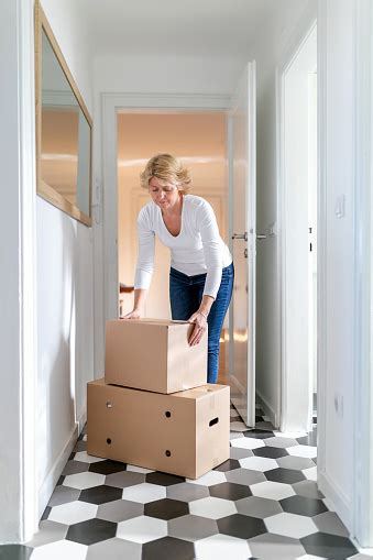 중년 여성은 새로운 가정에서 다른 하나 위에 골판지 상자를 넣어 50 54세에 대한 스톡 사진 및 기타 이미지 50 54세 가정 생활 가정의 방 Istock