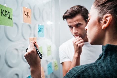 지능형 Coworking 사람들 Prepearing 비즈니스 전략 및 스티커 유리 참고 벽에 게시 새로운 사업 아이디어를 브레인 스토밍 관리자 팀 2명에 대한 스톡 사진 및