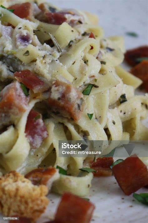 카보나라 소스에 계란 베이컨 프로슈토 햄 판세타 이탈리아 파르메산 치즈와 마늘 화이트 플레이트에 부분 전경에 초점을 맞춘 카르보나라 소스에 홈메이드 페투치네 파스타의