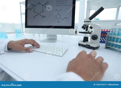 a scientist uses a computer and a microscope stock image image of