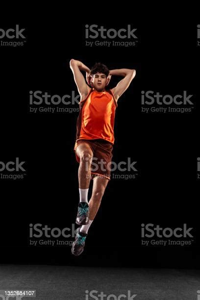 어두운 스튜디오 배경에 고립 된 농구 선수 훈련의 전체 길이 초상화 키가 큰 근육질 운동 선수가 공을 가지고 점프합니다 18 19세에 대한 스톡 사진 및 기타 이미지
