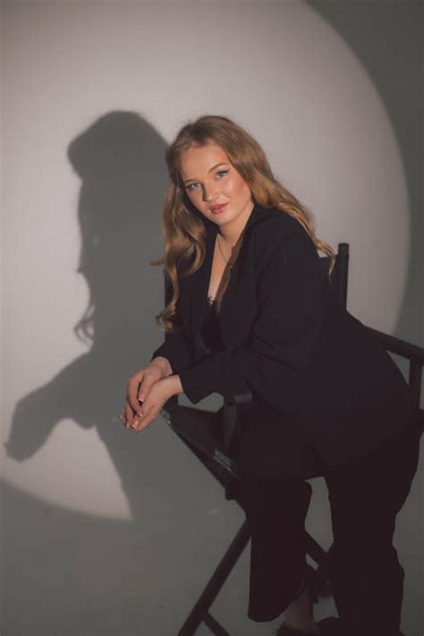 갈색 머리 검은 옷 그림자 높은 각도보기 모델 수직 쐈어 스튜디오 촬영 아름다운 여성 올려다보는 자주색 배경 젊은 컨템포러리 패션 포즈를 취하는