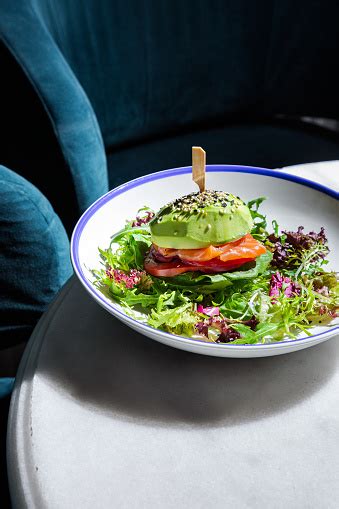 연어 아보카도 참깨 토마토 아루굴라 바질 엔디브 양배추를 소파로 둘러싸인 하얀 테이블 위의 접시에 담은 샐러드 0명에 대한 스톡 사진 및 기타 이미지 Istock