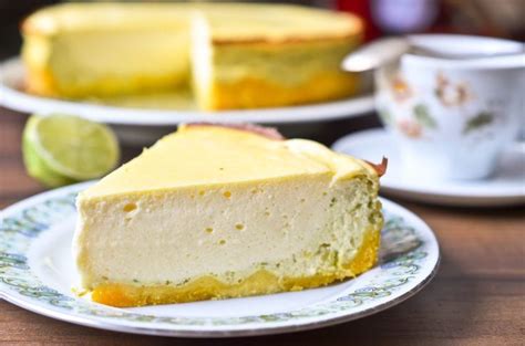 A Slice Of Cheesecake On A Plate With A Cup And Saucer In The Background
