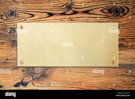 Brass Plaque With A Brush Metal Texture And Screws On A Wood Board