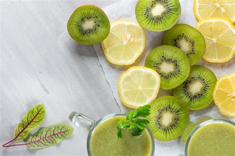 회색 콘크리트 배경에 키위 라임과 레몬으로 둘러싸인 건강한 신선한 과일 스무디 음료 건강한 라이프 스타일과 적절한 영양의 개념