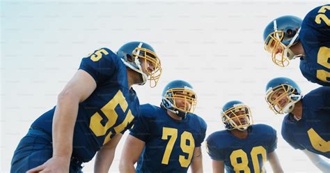 파란색 유니폼을 입은 프로 축구 선수 팀이 다음 태클에 대해 논의하는 낮은 각도 보기 사진 Unsplash의 대학 미식축구 이미지