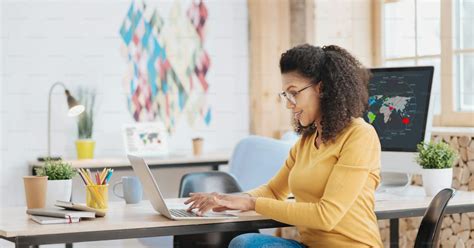 멋진 하루 꽤 즐거운 콘텐츠 젊은 곱슬머리 여자가 웃고 테이블에 앉아 노트북으로 작업하고 있다 사진 Unsplash의 우크라이나 이미지