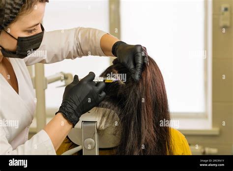 esthetician uses thin needle to inject platelet rich plasma in scalp