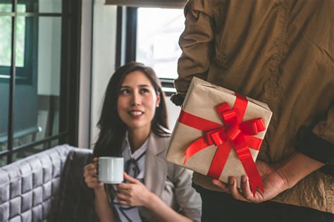 남자가 그의 여자 친구에 대 한 그의 뒤의 뒤에 깜짝 선물을 숨기고 있다 사랑과 관계 개념 기념일에 대한 스톡 사진 및 기타